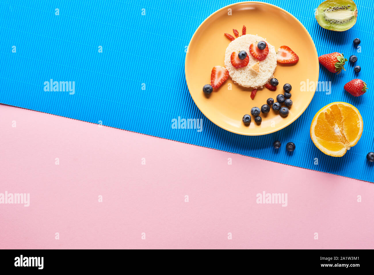 top view of plate with fancy animal made of food on blue and pink ...