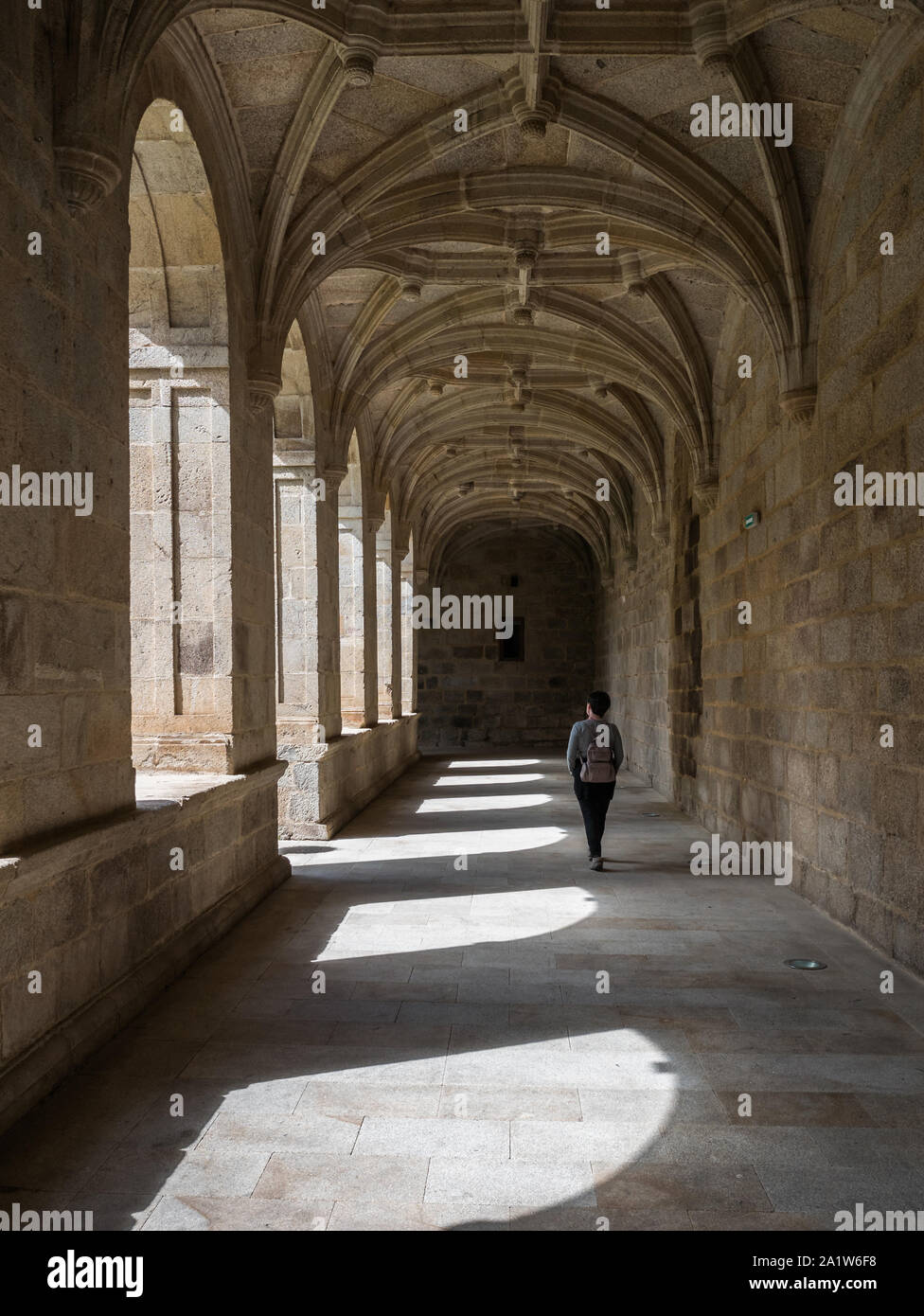 A female traveller walking through the cloister of the San Clodio ...