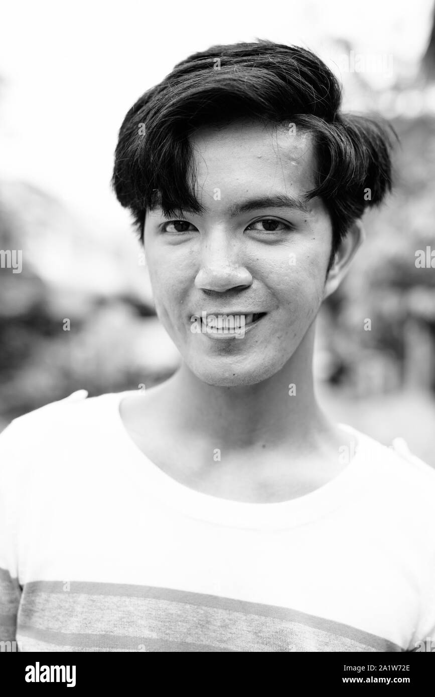 Young handsome Asian man smiling in the streets outdoors Stock Photo ...