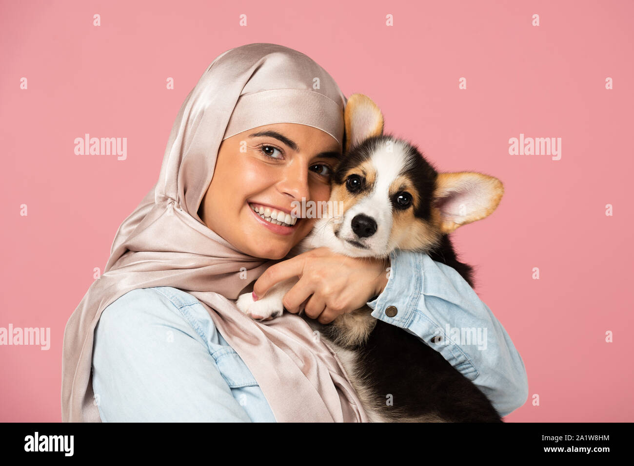 attractive muslim girl in hijab holding Welsh Corgi puppy, isolated on ...