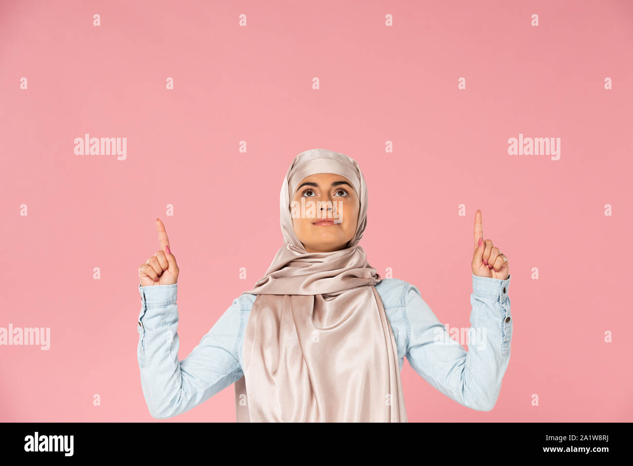 beautiful islamic woman in hijab pointing up, isolated on pink Stock ...