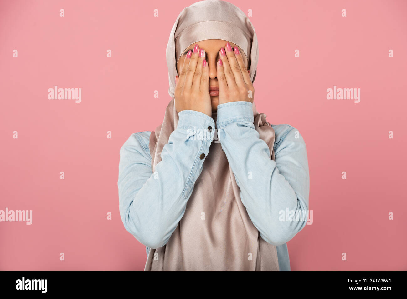 beautiful scared muslim girl in hijab closing eyes, isolated on pink ...