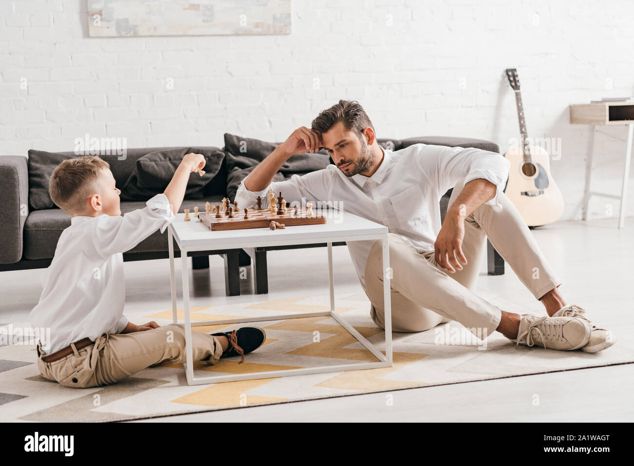 dad and son playing chess together at home Stock Photo - Alamy