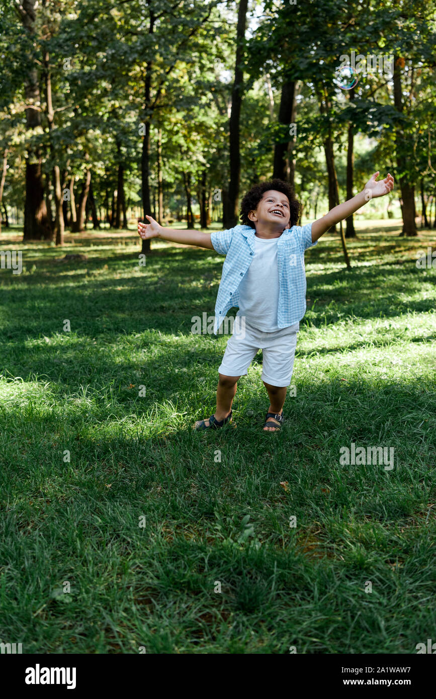 happy african american kid with outstretched hands in park Stock Photo ...