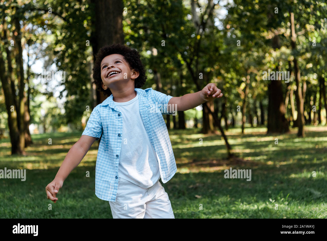 happy african american boy looking up in park Stock Photo - Alamy