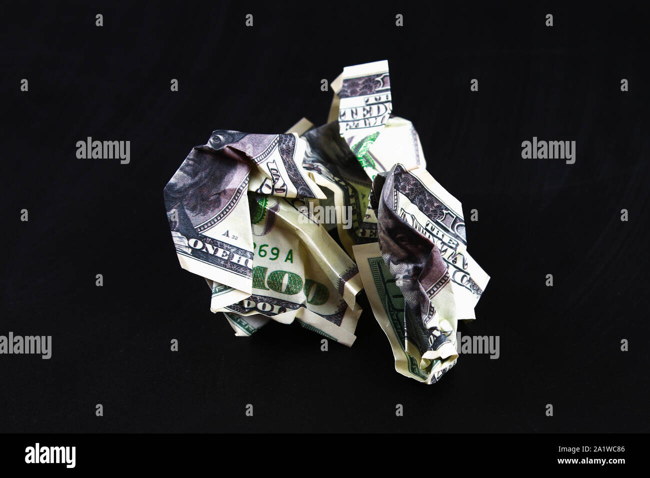 Crumpled one hundred American dollar on black paper background, close ...