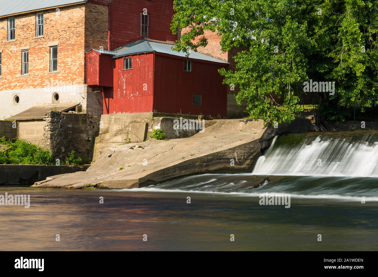 An old grist mill by a river with a dam Stock Photo - Alamy