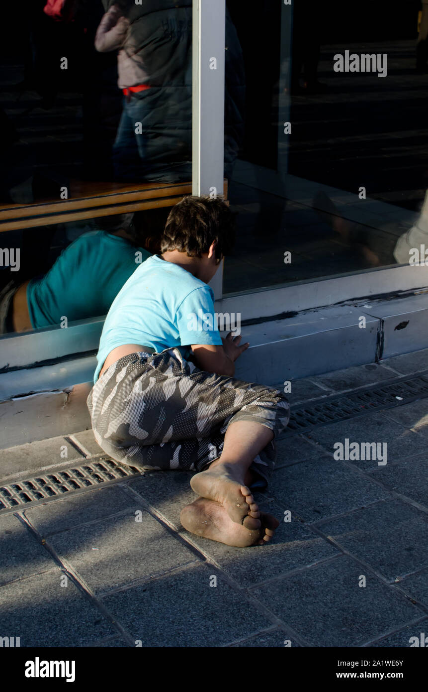 Istanbul, Turkey, March 07,2019: homeless young barefoot boy lying next ...