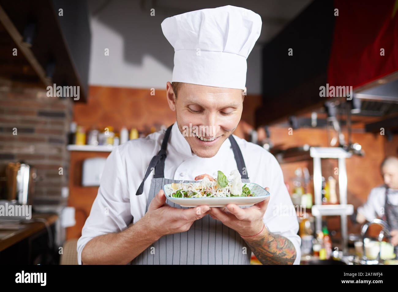Waist up portrait of smiling professional chef holding beautiful Asian ...