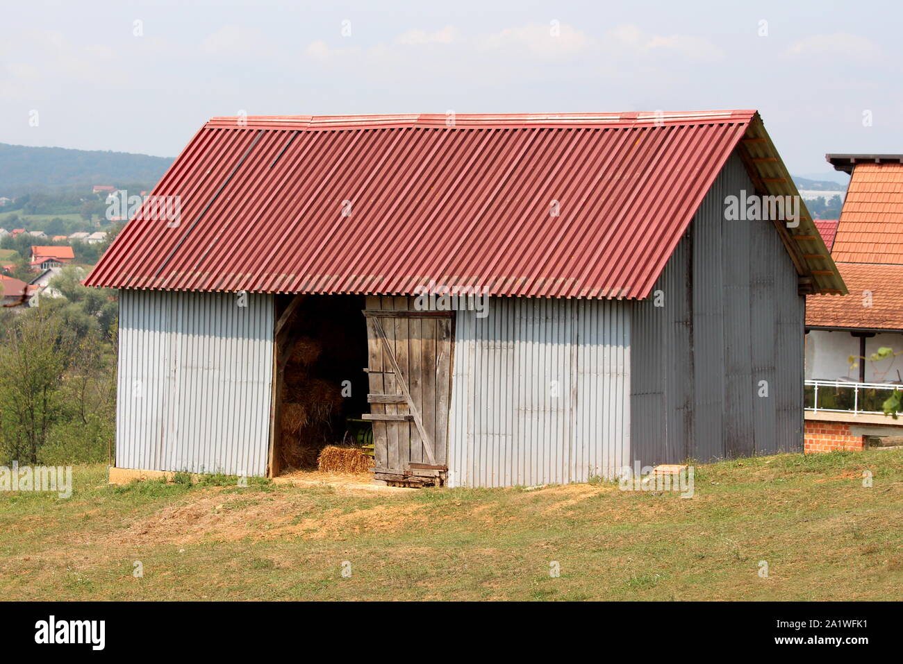Newly built outdoor barn covered with large red and grey metal sheets ...