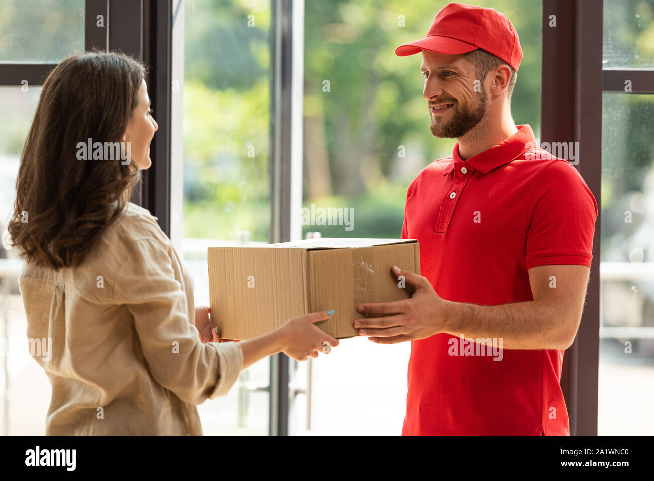 happy woman receiving carton box from delivery man Stock Photo - Alamy