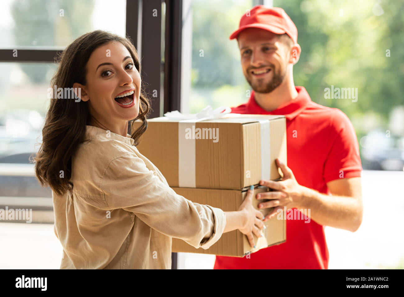 selective focus of happy woman receiving carton boxes from cheerful ...
