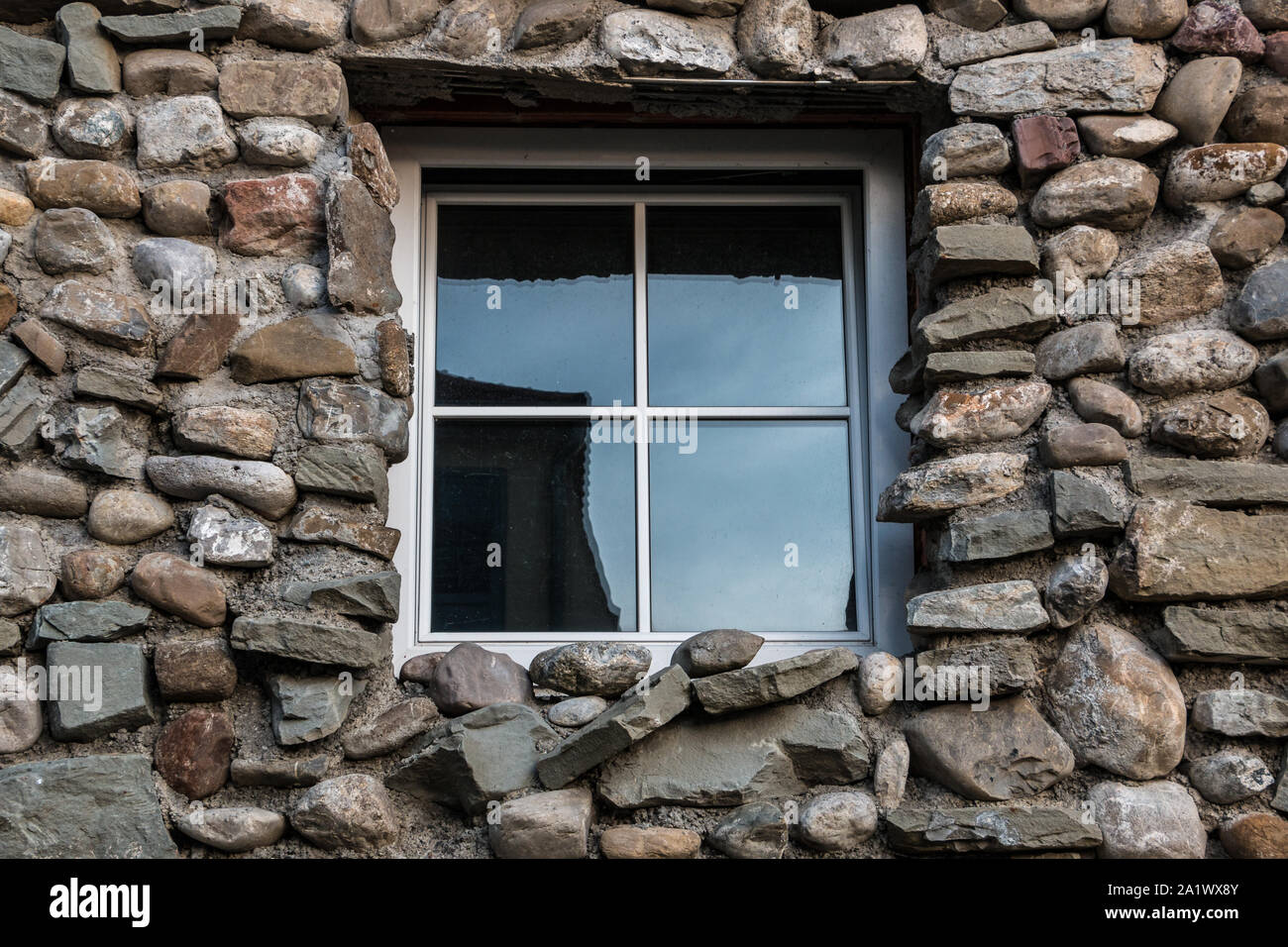 Natural stone wall with colorful and different sized stones and window ...