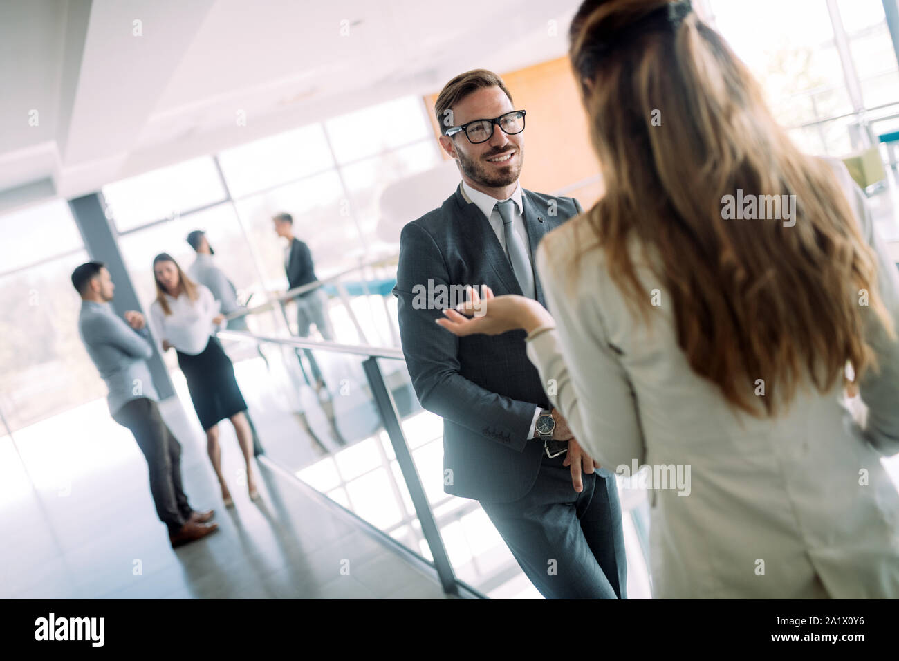 Business people discussing over documents in office lobby Stock Photo ...