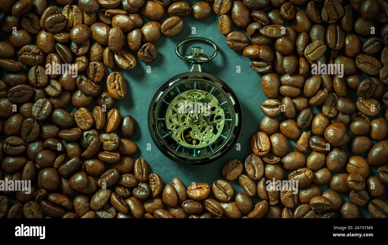 Coffee bean around pocket watch on table in morning. Concept of coffee ...