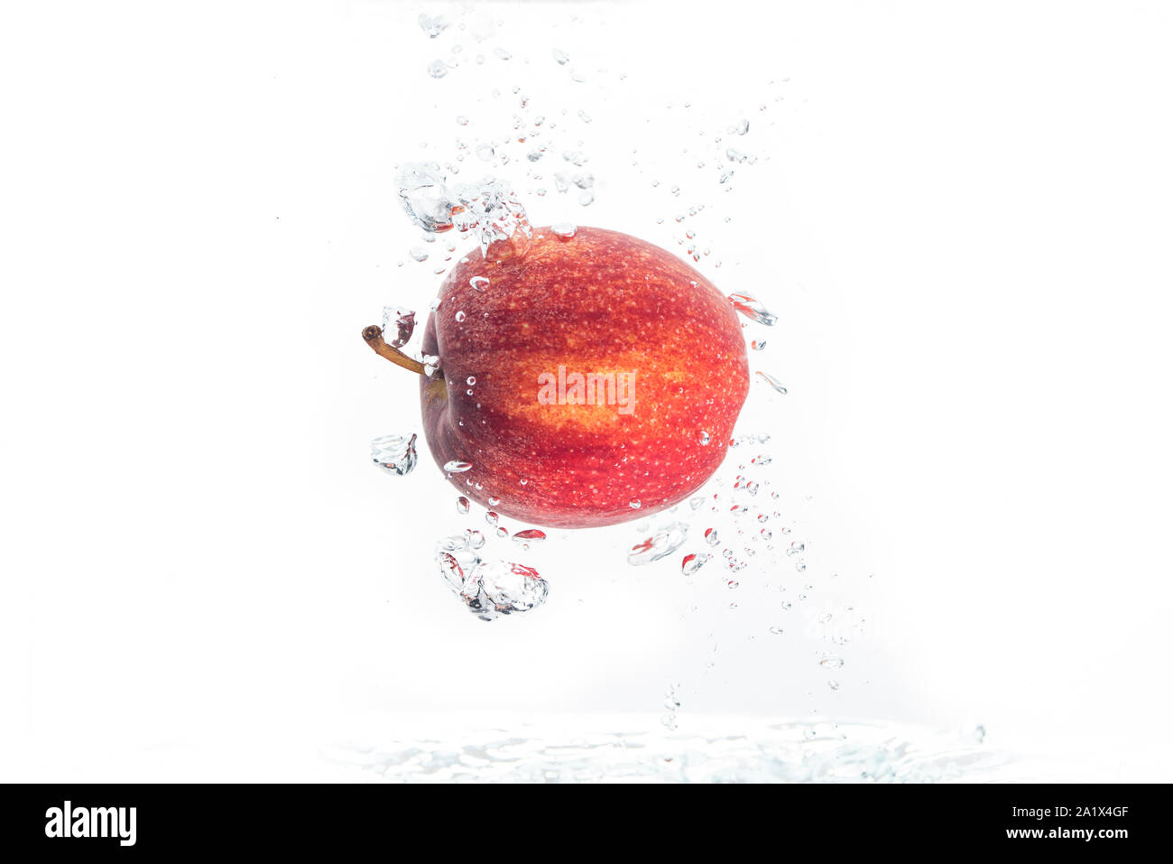Apple falls under water with a splash Stock Photo - Alamy
