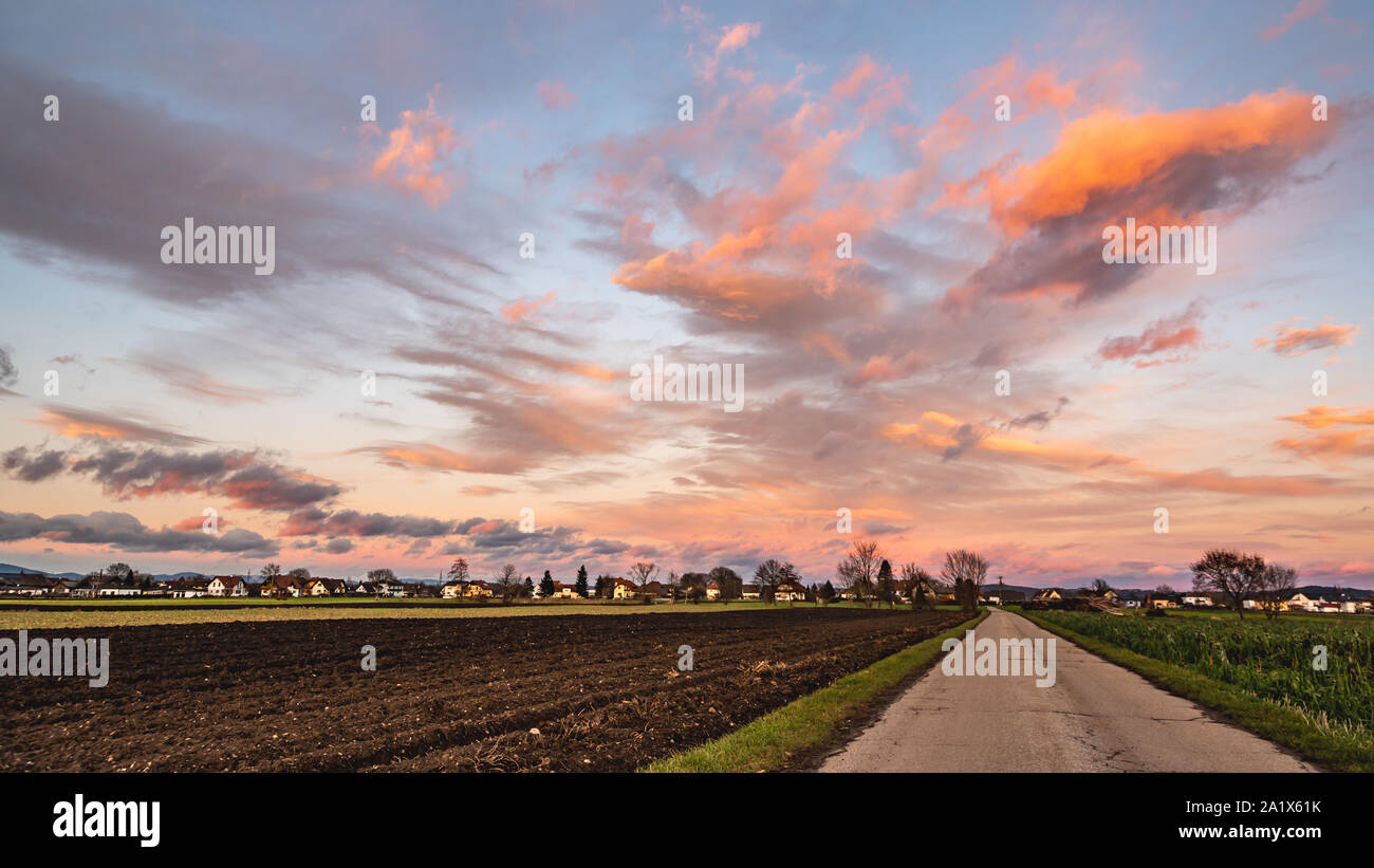 Sunset over village with dramatic sky Stock Photo - Alamy