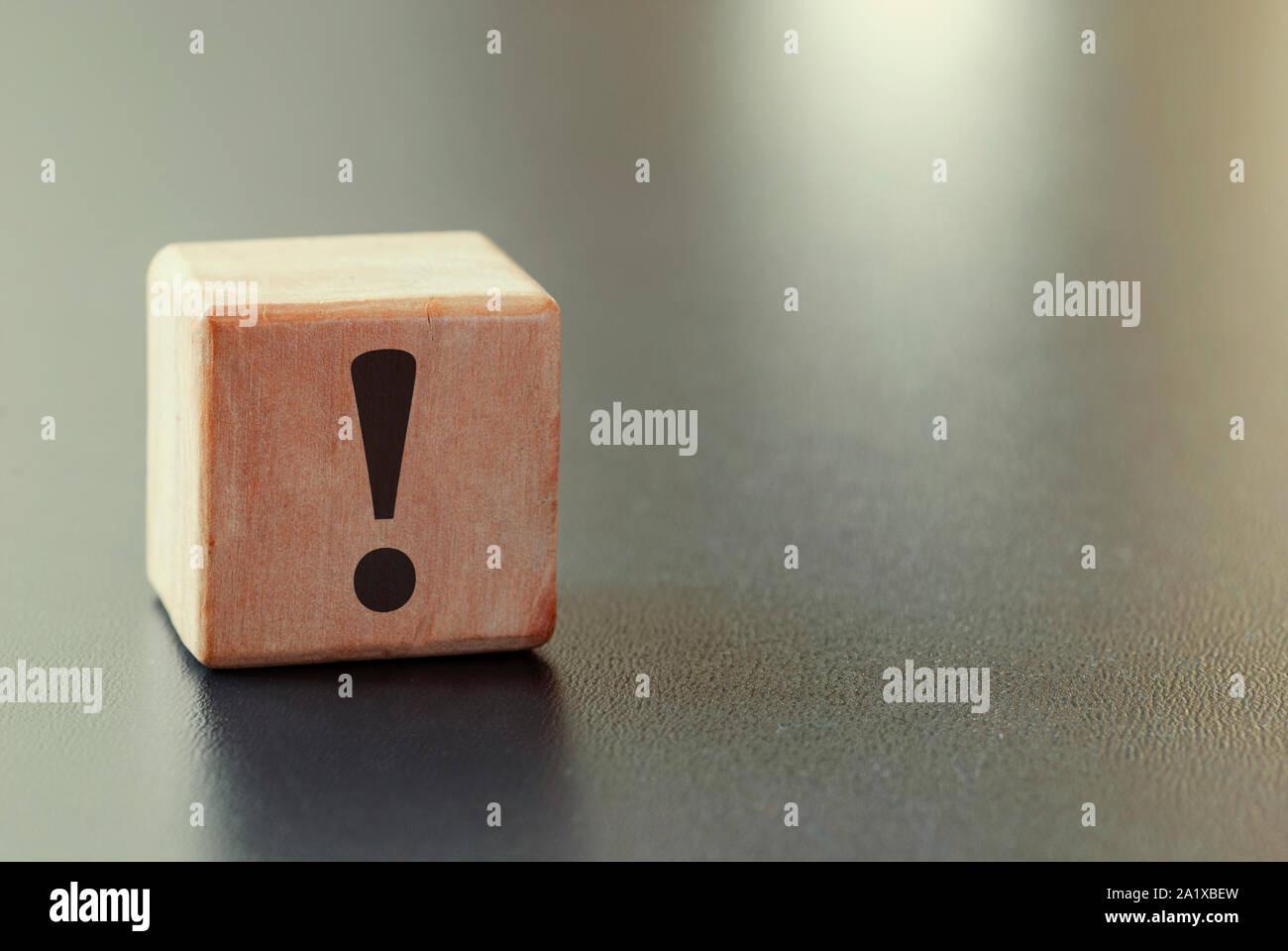 Small wooden block with exclamation mark in black on the side over a ...