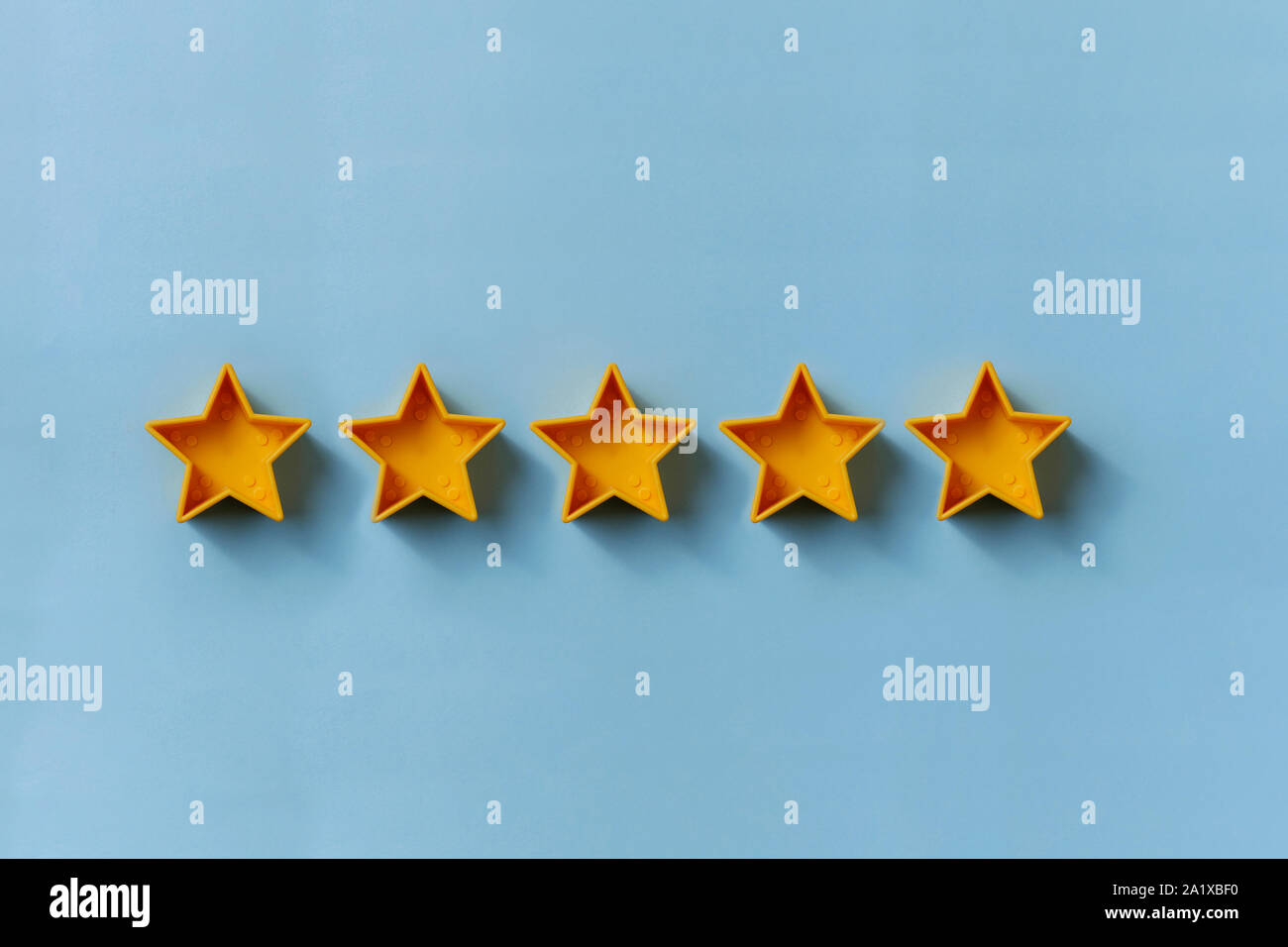 Row of five gold stars for excellence and quality centered over a blue ...