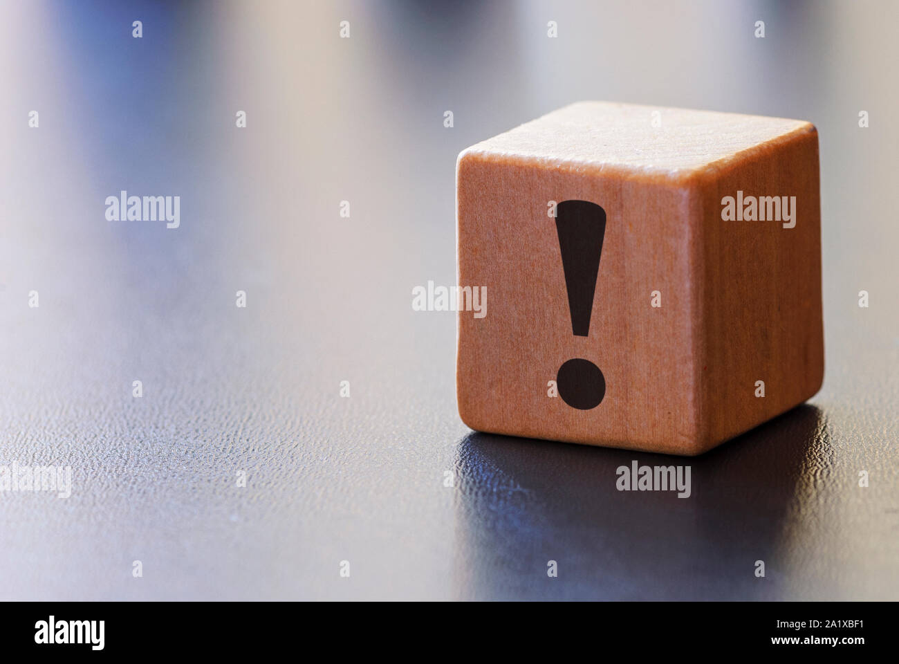 Warning exclamation mark on a wooden block to attract attention over a ...