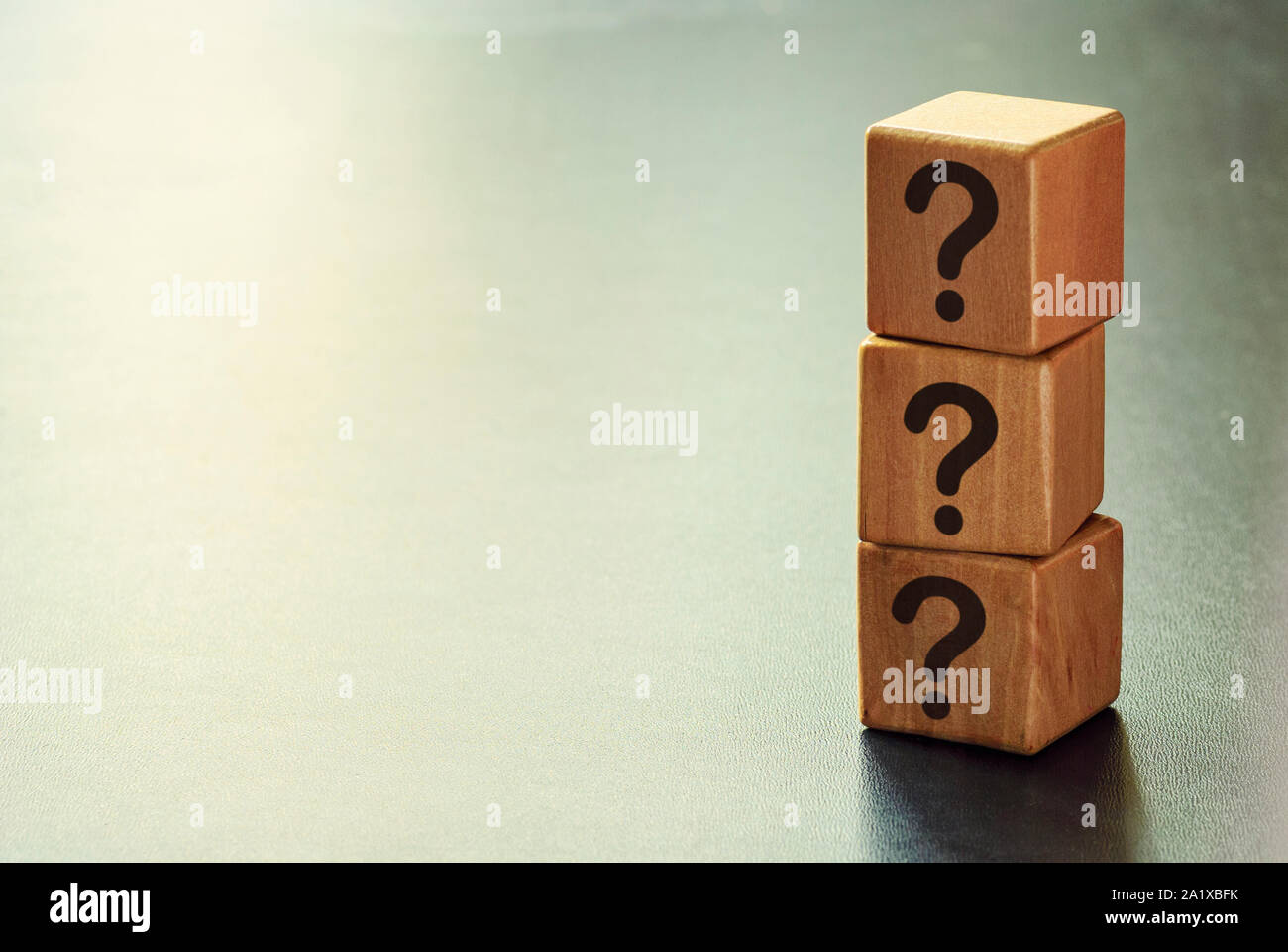 Stack of three wooden cubes with question marks forming a side border ...