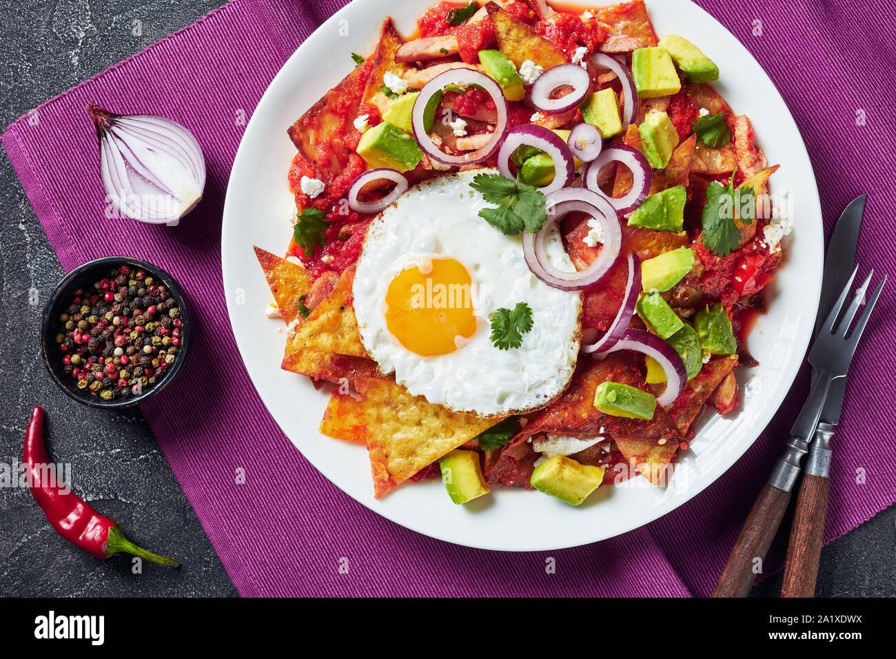 nachos with a fried sunny side up egg, ham, crumbled panela cheese ...