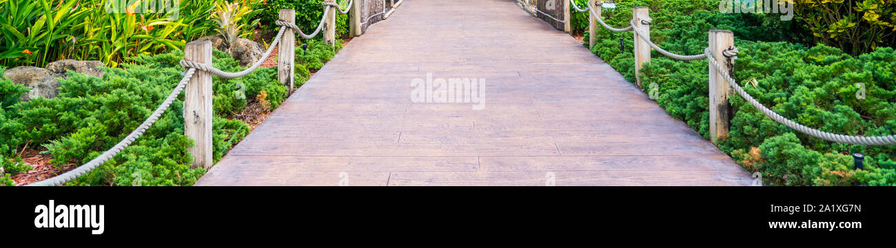 Wooden path in nice park in spring Stock Photo - Alamy