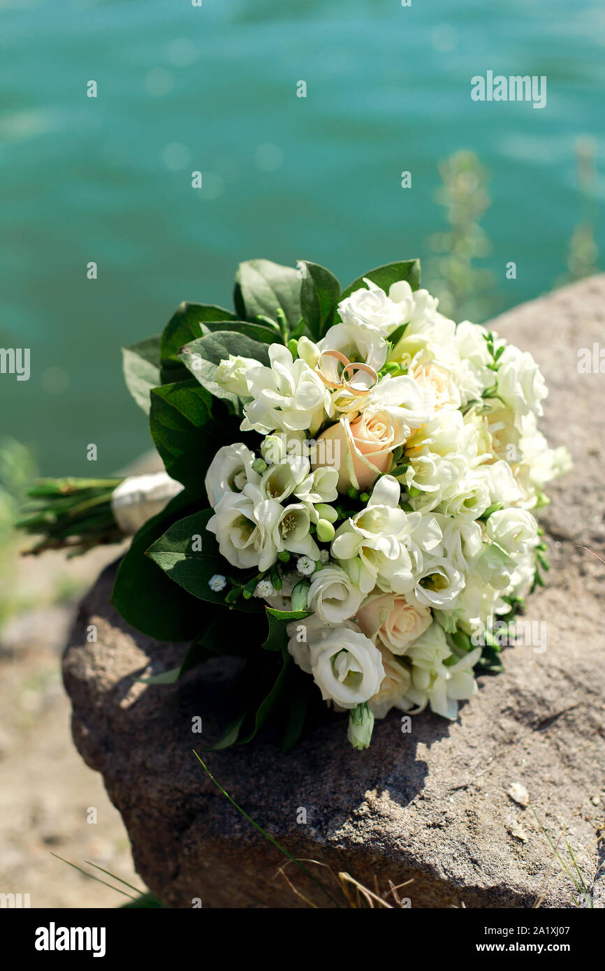 a bouquet of white roses on the stone bank of the river Stock Photo - Alamy