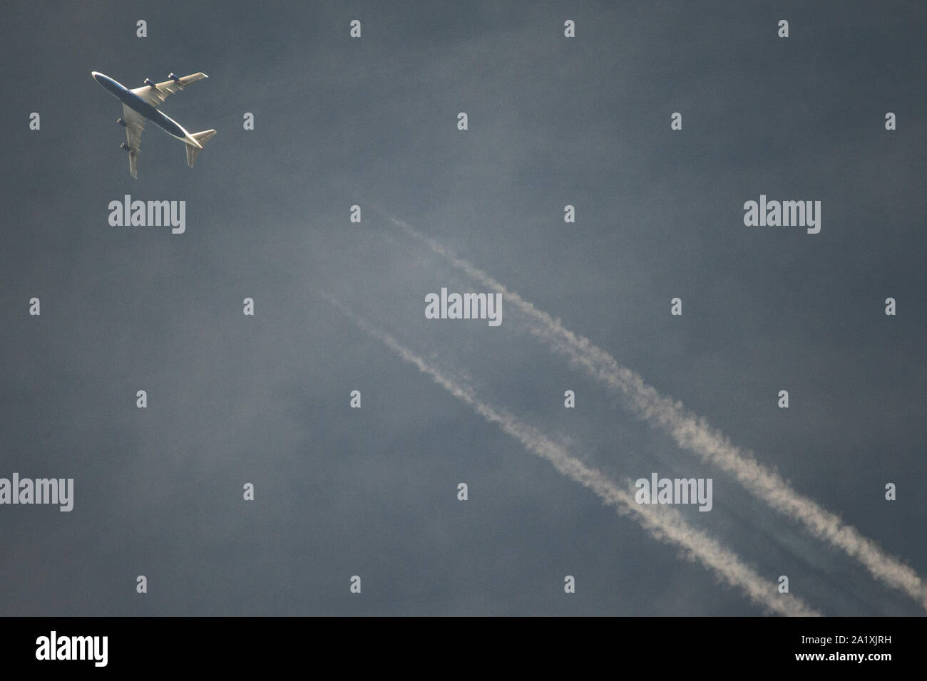 High flying jumbo jet leaving trail behind in the sky hi-res stock ...