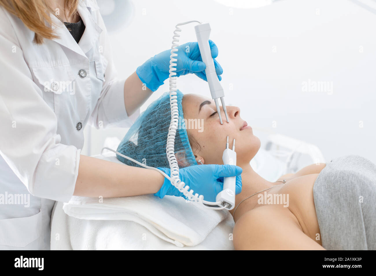 Portrait of a young beautiful girl face microcurrent therapy procedure ...