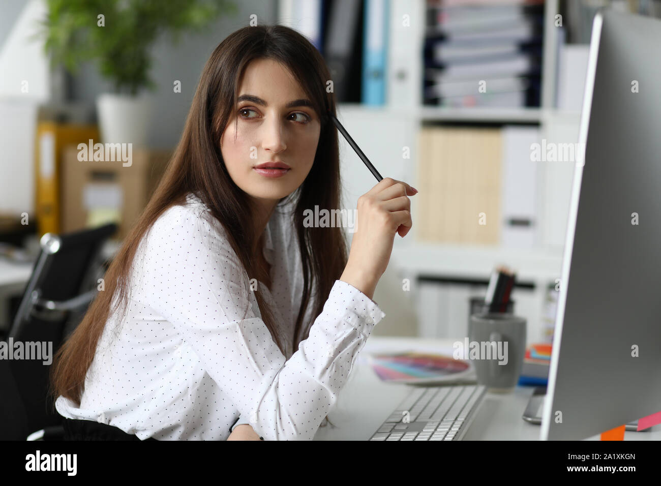Pretty woman holding pen Stock Photo - Alamy