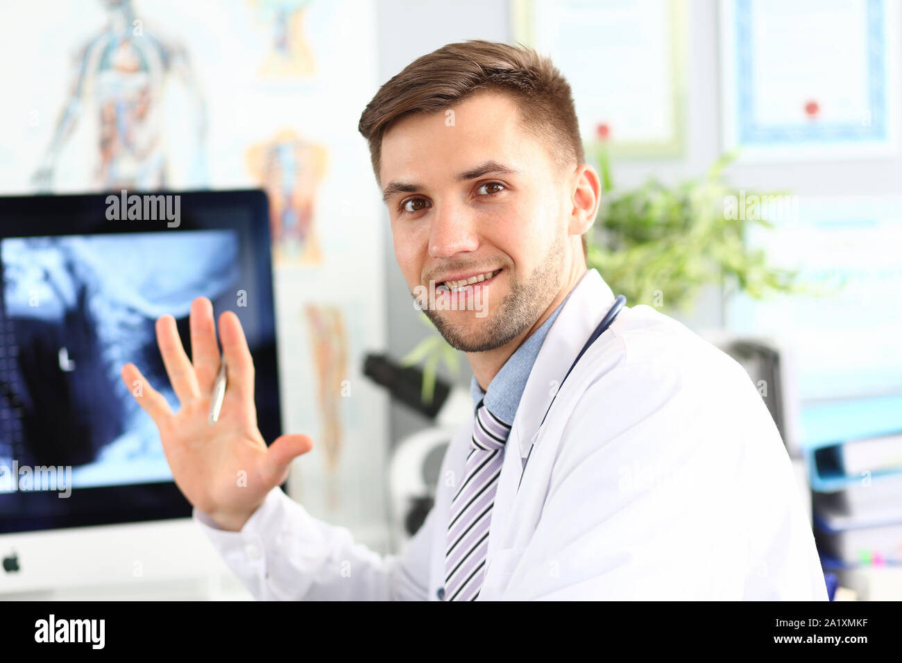 Doctor waving hello at camera Stock Photo - Alamy