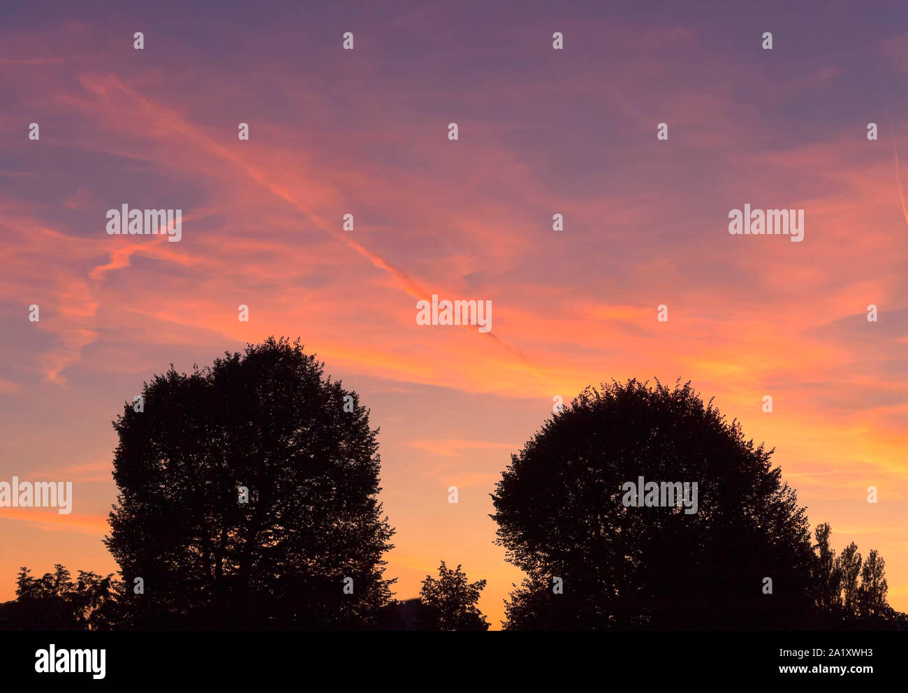 Sunset with contrails Stock Photo - Alamy