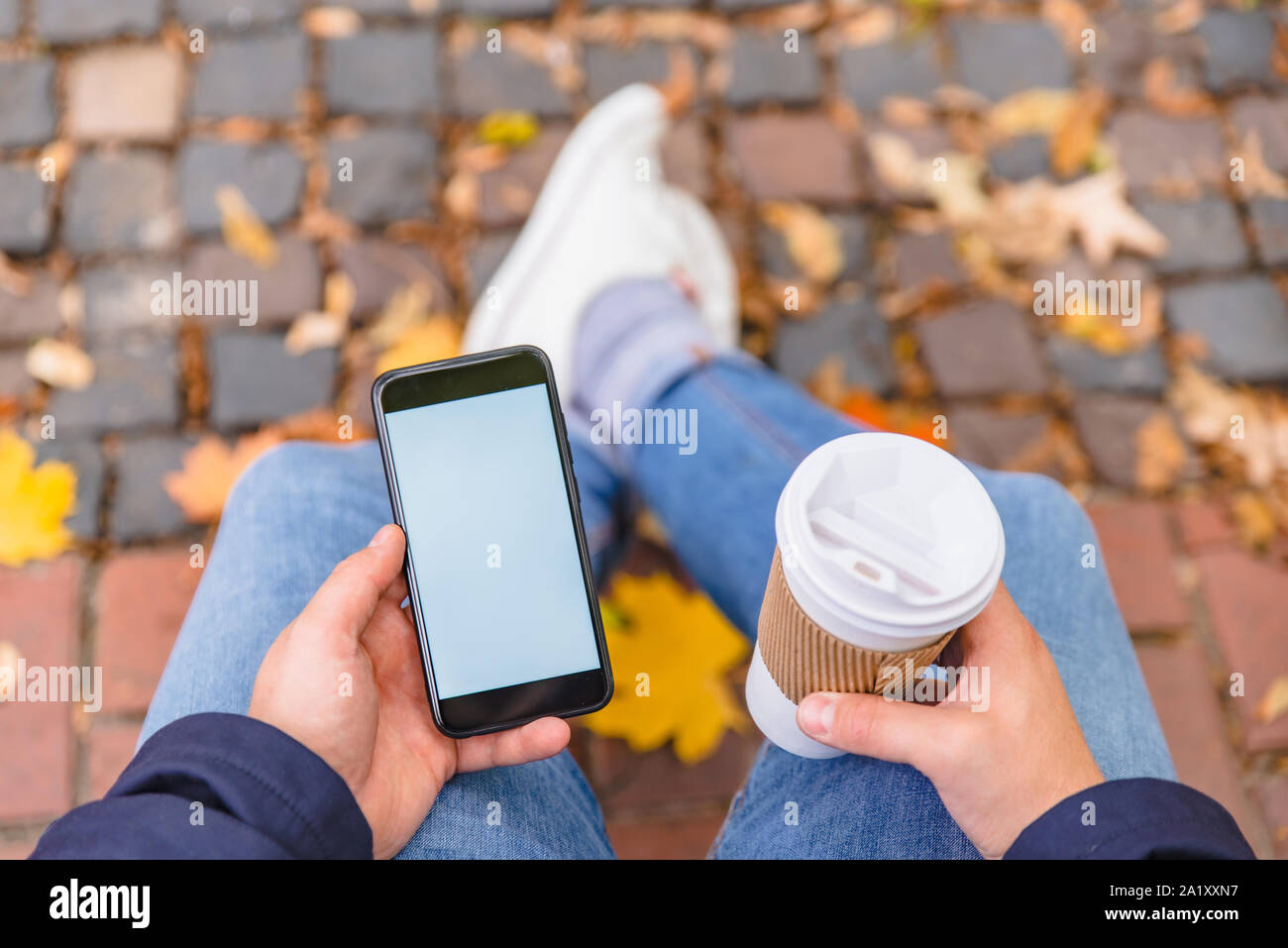 no face man sitting on the bench at city park drinking coffee surfing ...
