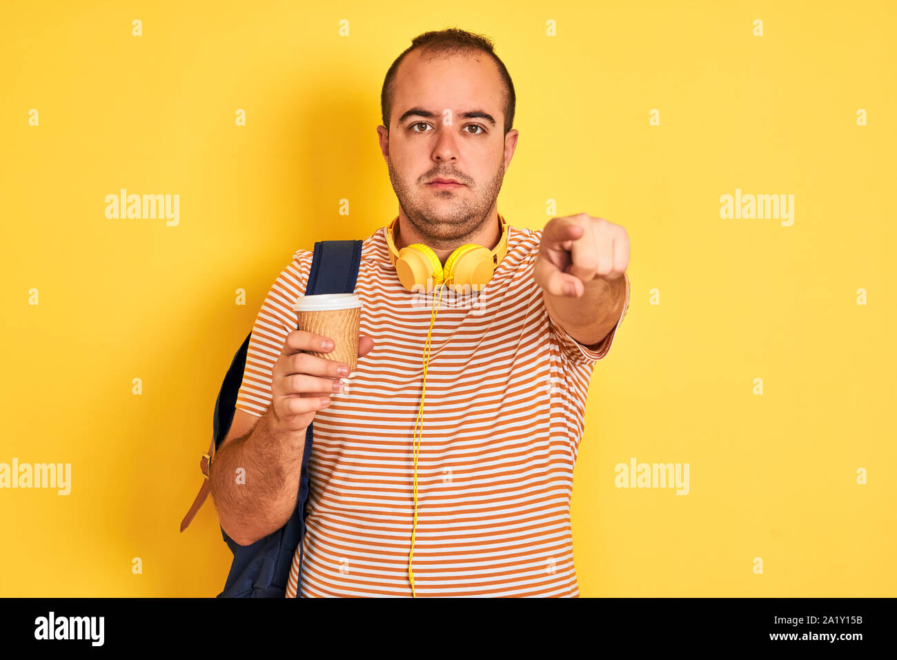 Student man wearing backpack headphones drinking coffee over isolated ...