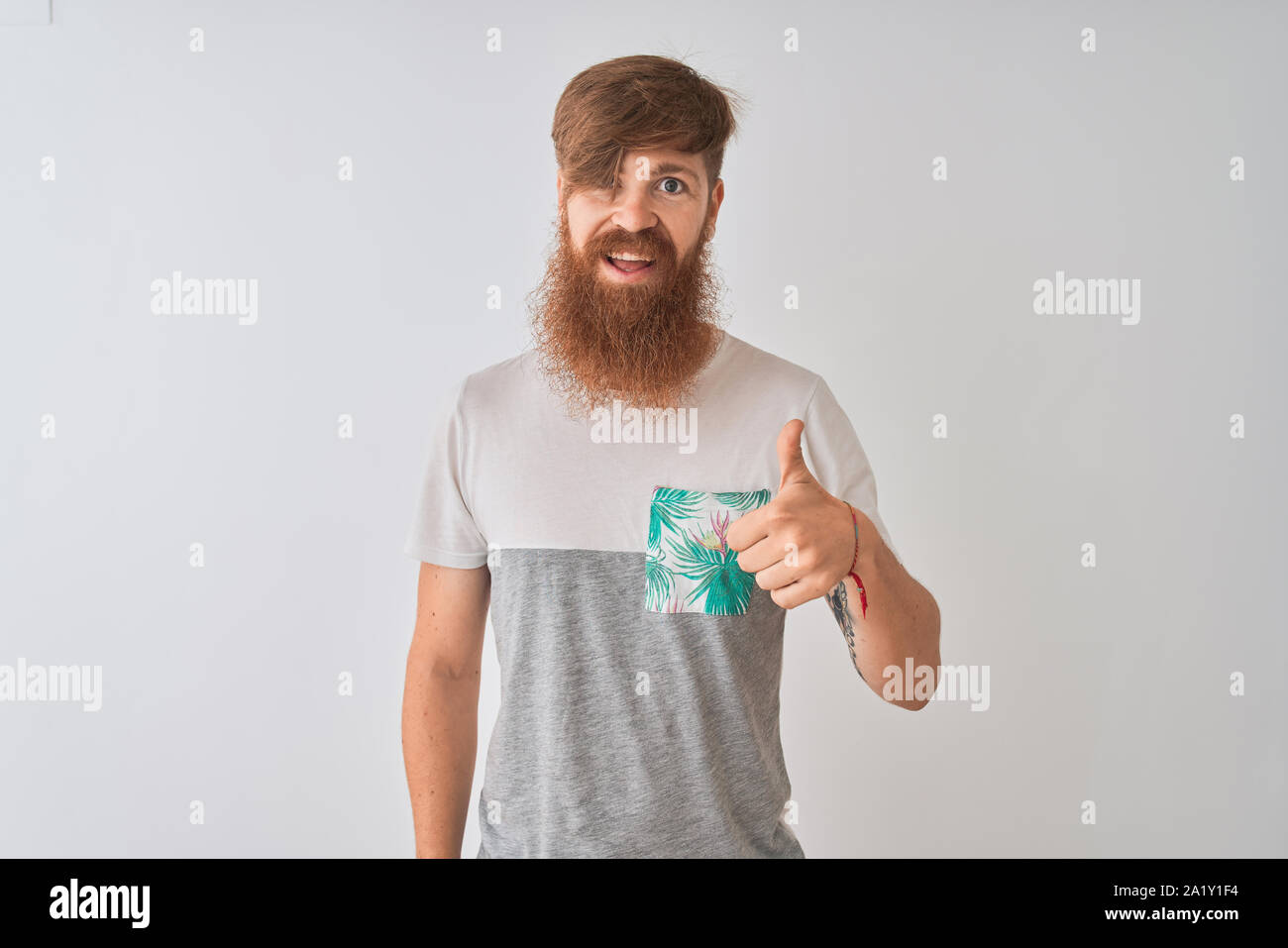 Young redhead irish man wearing t-shirt standing over isolated white ...