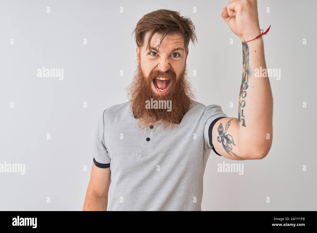 Young redhead irish man wearing grey polo standing over isolated white ...