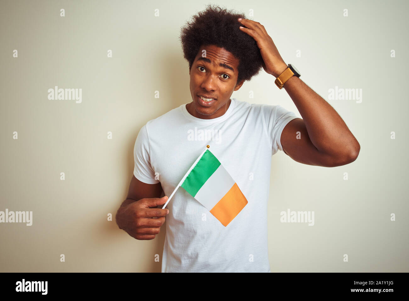 Young african american man holding Ireland Irish flag standing over ...