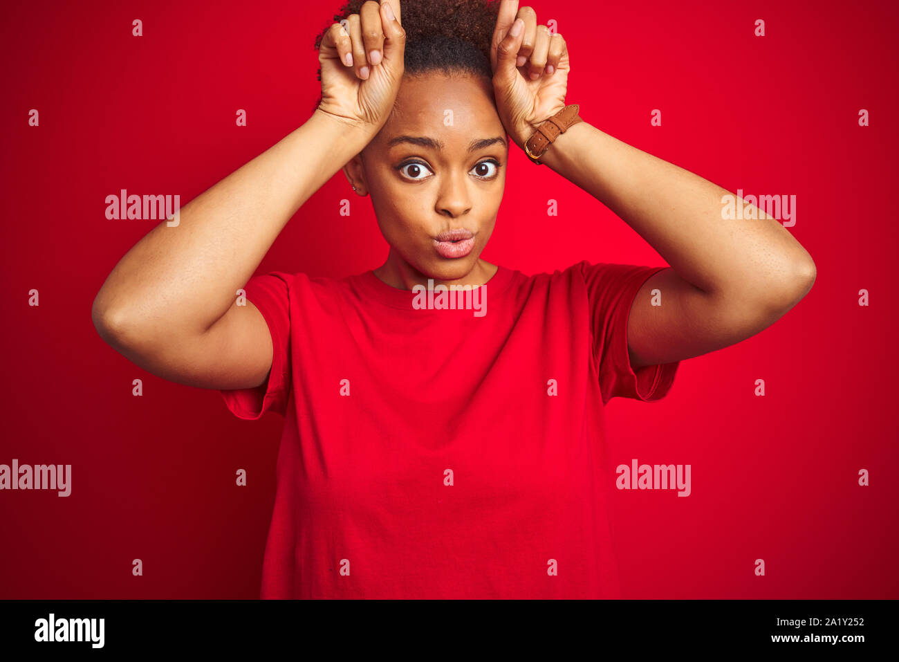Young beautiful african american woman with afro hair over isolated red ...