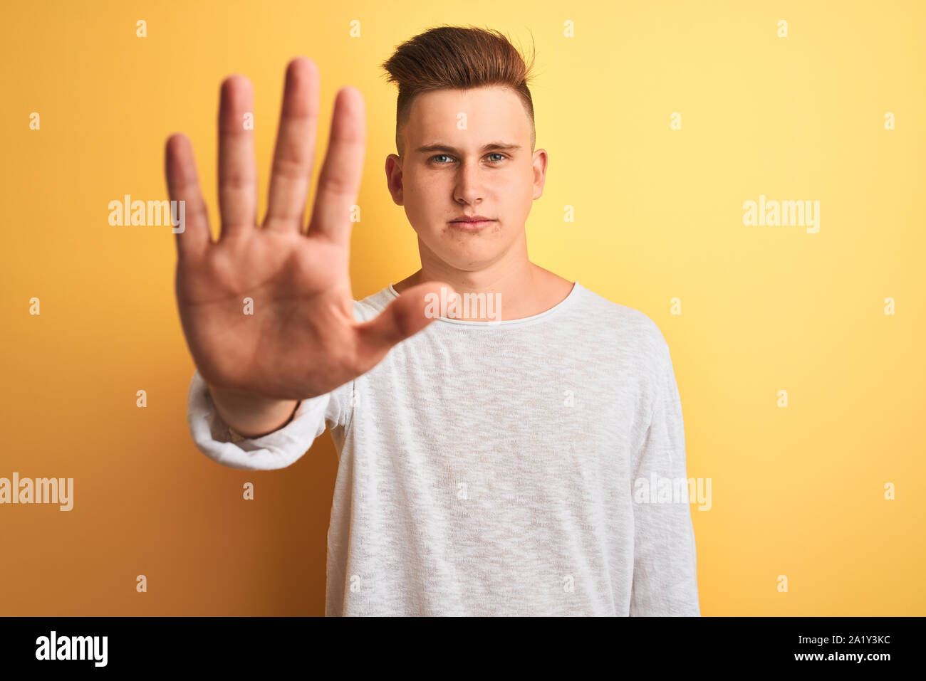 Young handsome man wearing white casual t-shirt standing over isolated ...
