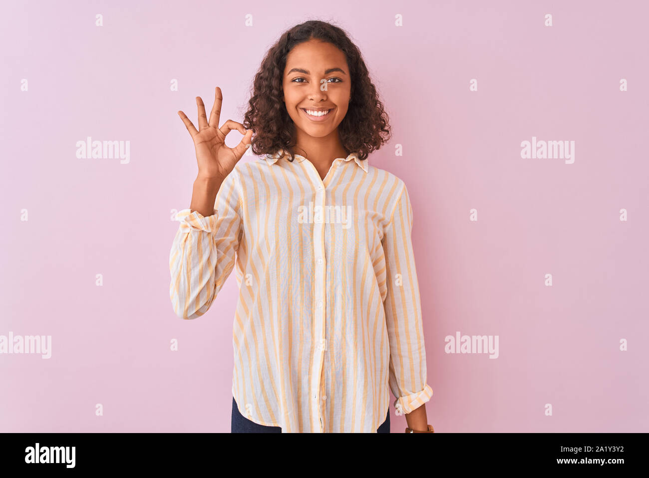 Young Brazilian Woman Wearing Striped Shirt Standing Over Isolated Pink