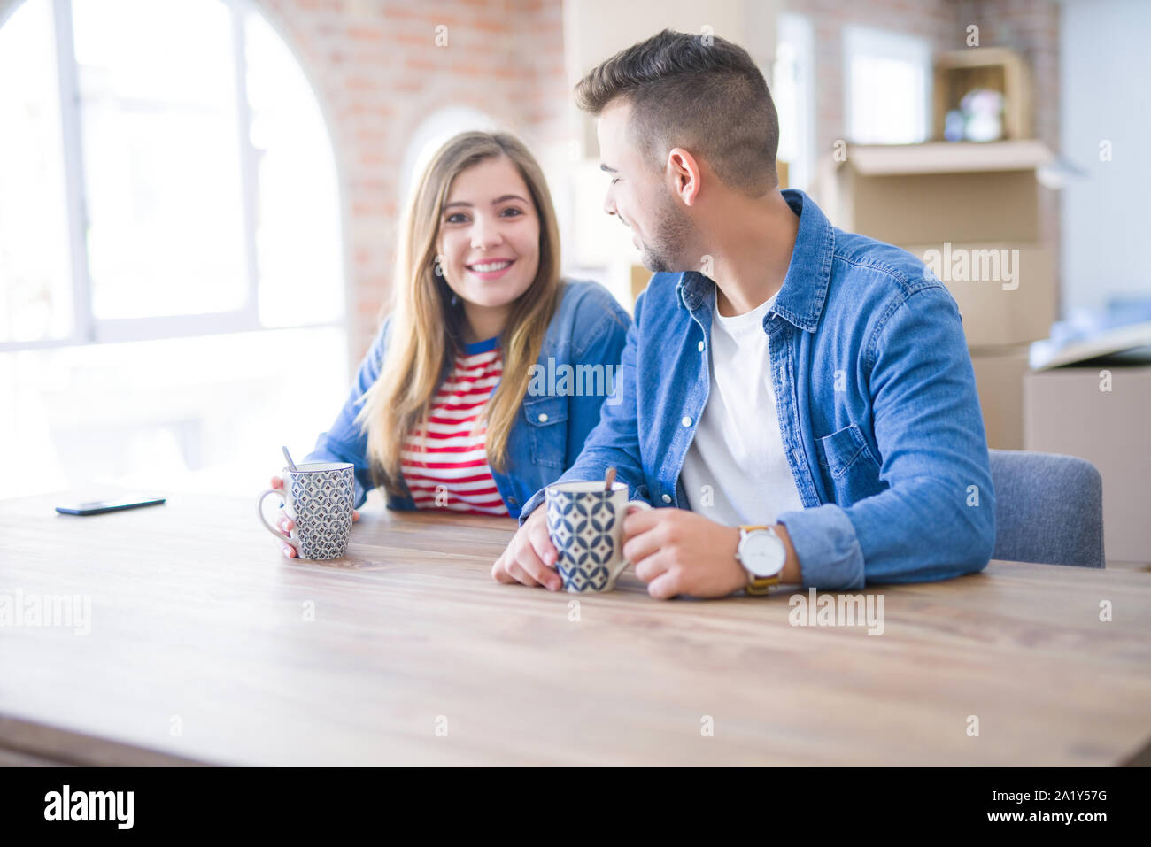 Young couple taking a break drinking a cup of coffee, very happy for ...