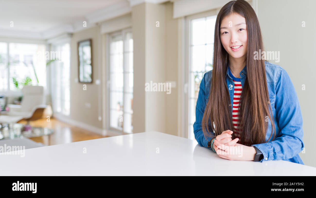 Young beautiful asian woman with long hair wearing denim jacket with ...