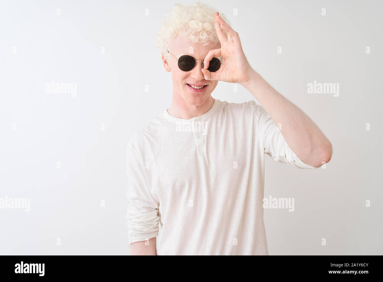 Young albino blond man wearing t-shirt and sunglasses over isolated ...