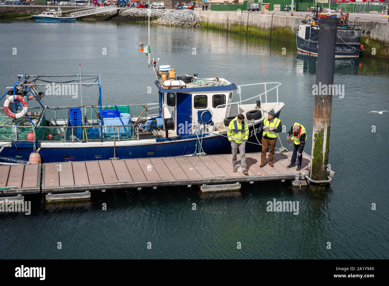 Oceanographers and tide gauge observers taking sea level measurements ...