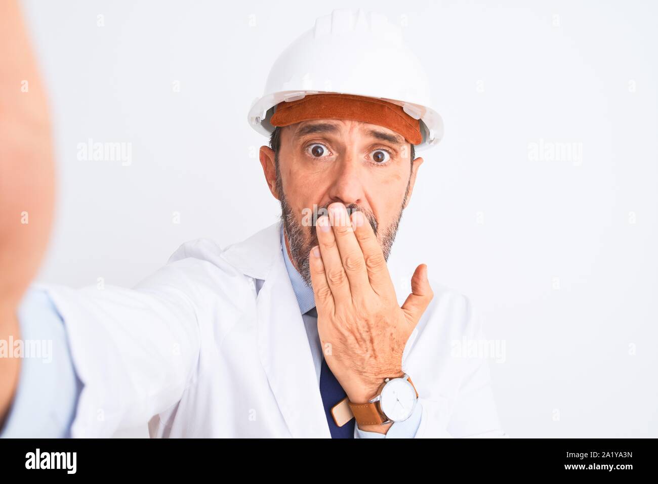 Middle age engineer man wearing helmet make selfie over isolated white ...
