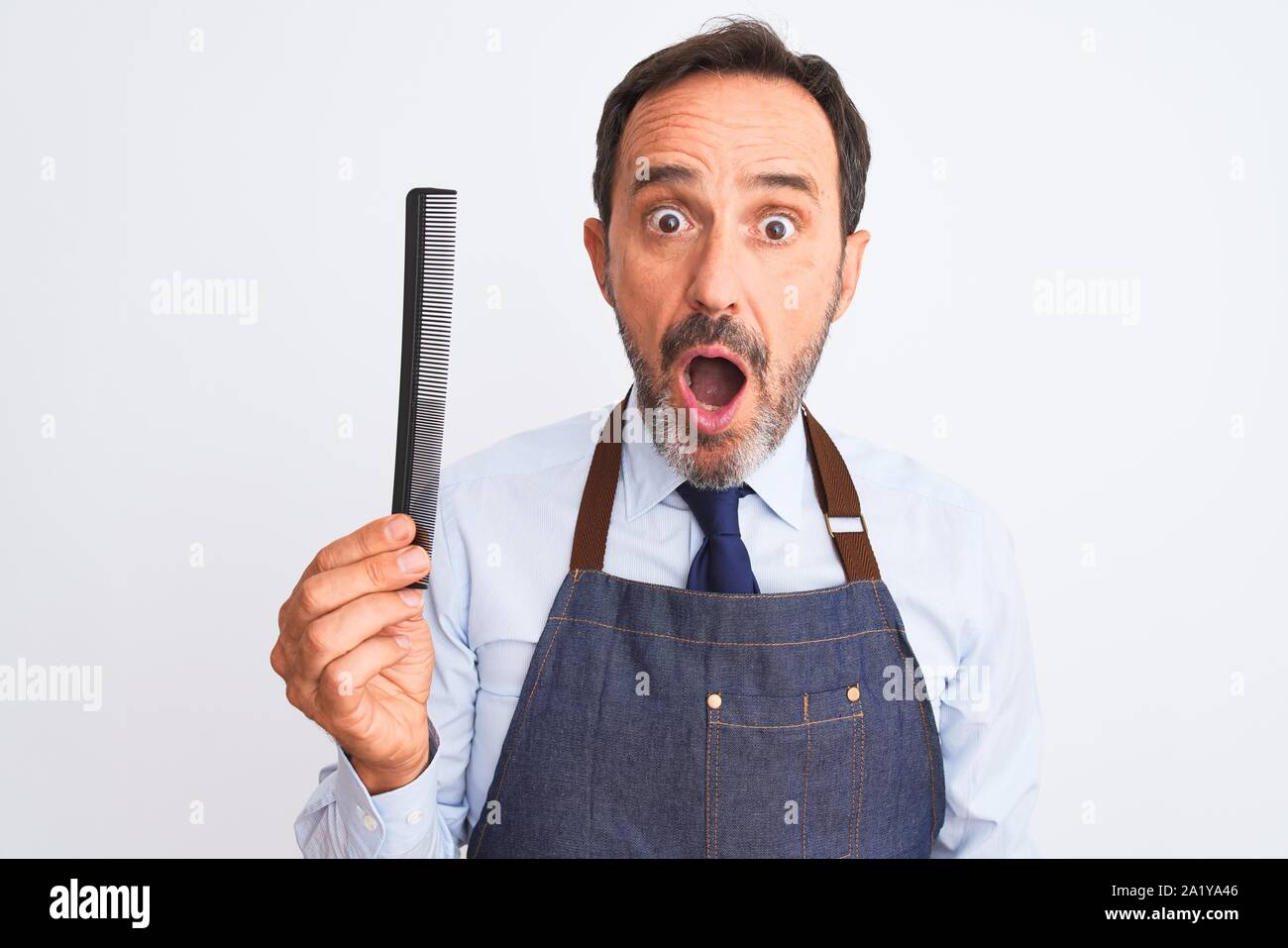 Middle age barber man wearing apron holding hair comb over isolated ...