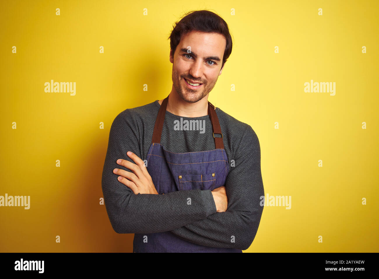 Young handsome shopkeeper man wearing apron standing over isolated ...