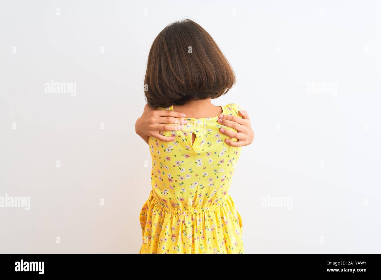 Young beautiful child girl wearing yellow floral dress standing over ...