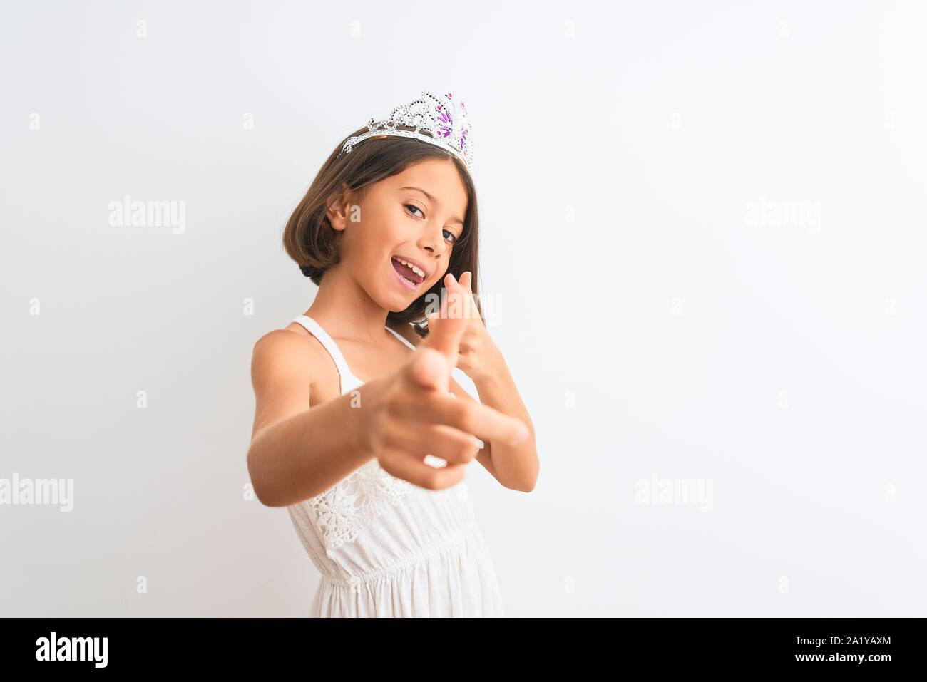 Beautiful child girl wearing princess crown standing over isolated ...